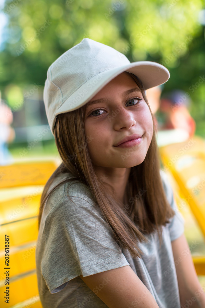 Cute teen girl portrait in cap outdoors. Stock Photo | Adobe Stock