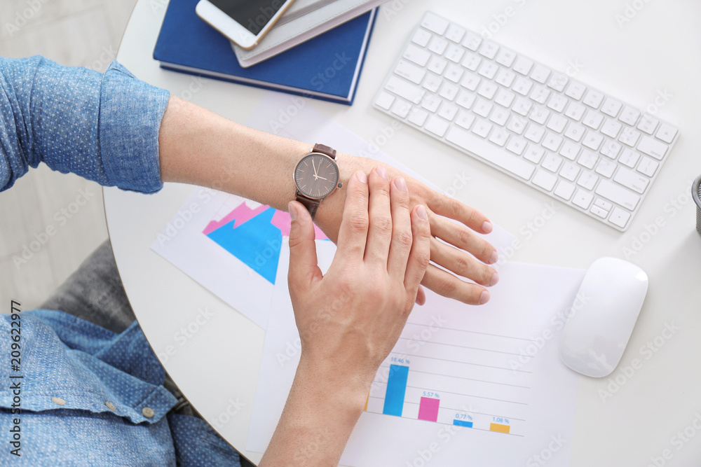 Young businessman checking time on his wristwatch at workplace, top ...