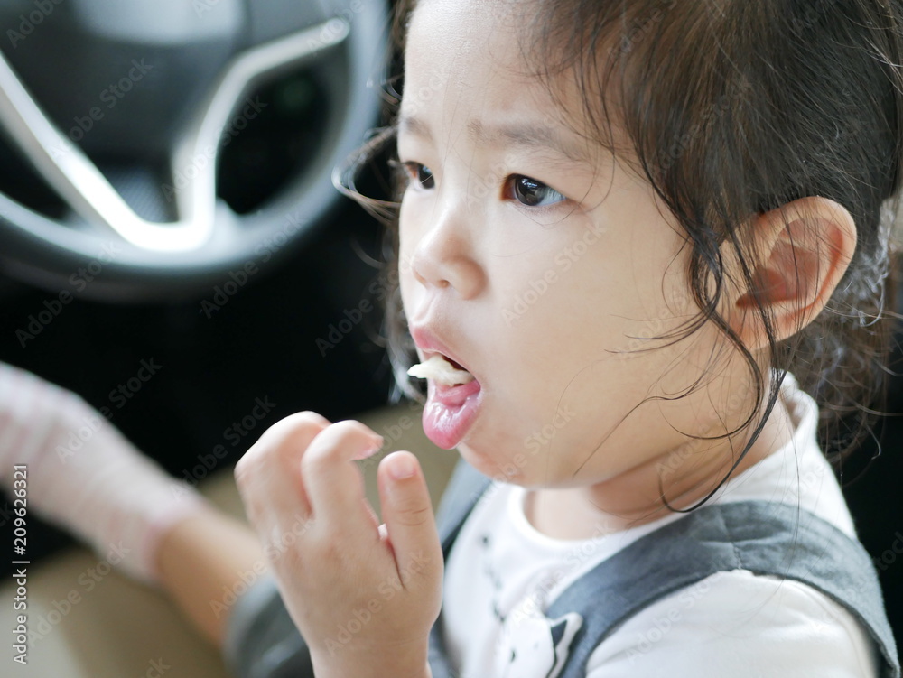 Little Asian baby girl, 24 months old, is choking while eating a piece ...