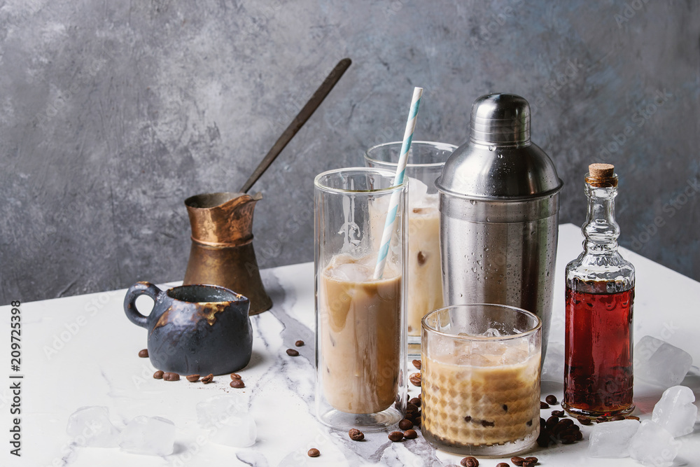 Iced coffee cocktail or frappe with ice cubes and cream in different ...