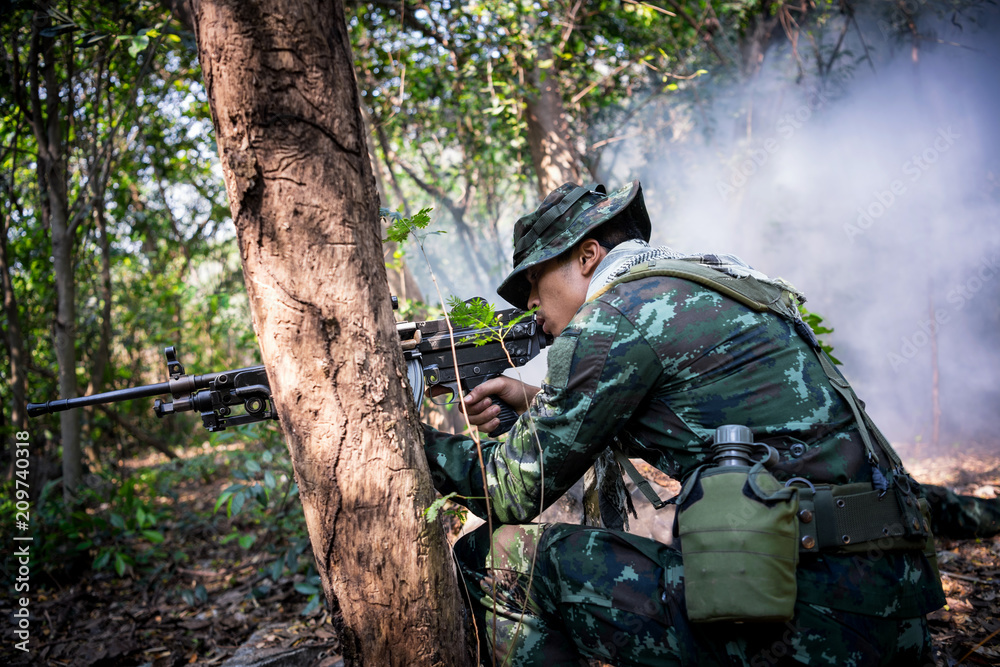 Special forces soldier or private military holding gun aiming behind a ...