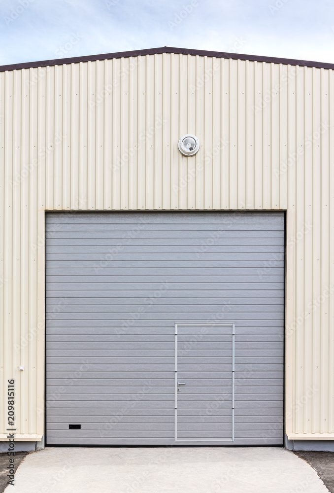 industrial warehouse exterior. closed gray metal gate with door Stock ...