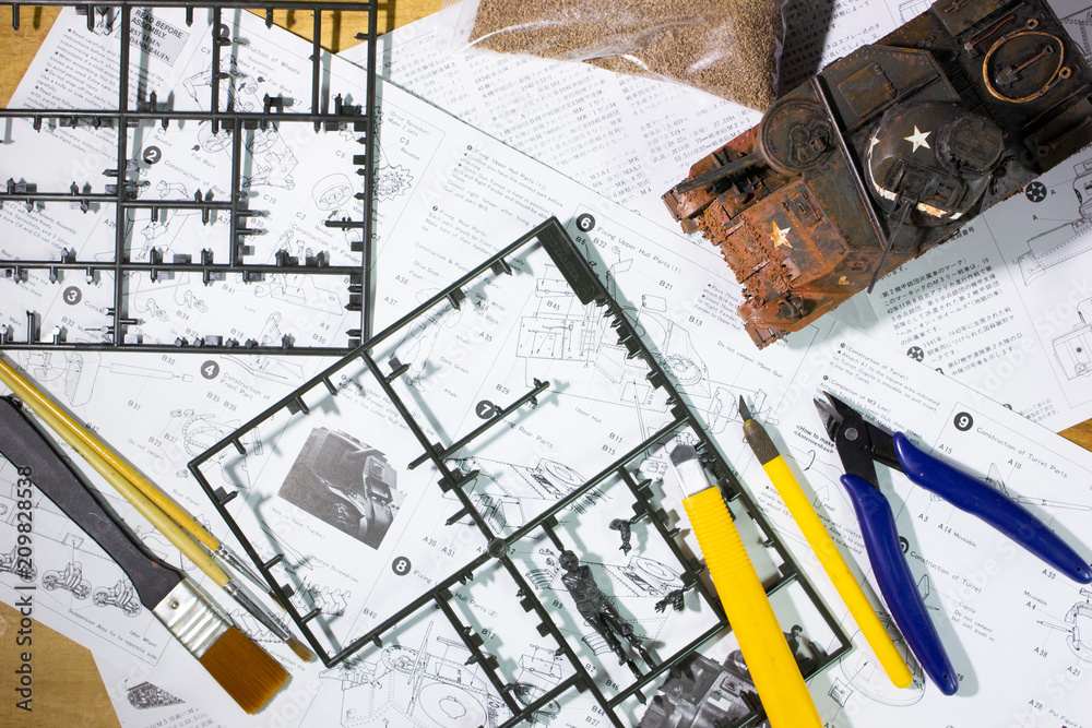 Plastic model WW2 tank M3 Lee with part and tools on wooden workbench ...