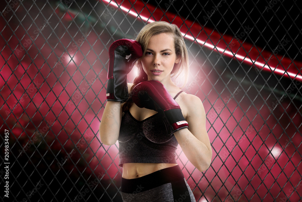 charming blonde woman mma fighter in red corner of the cage looking at ...
