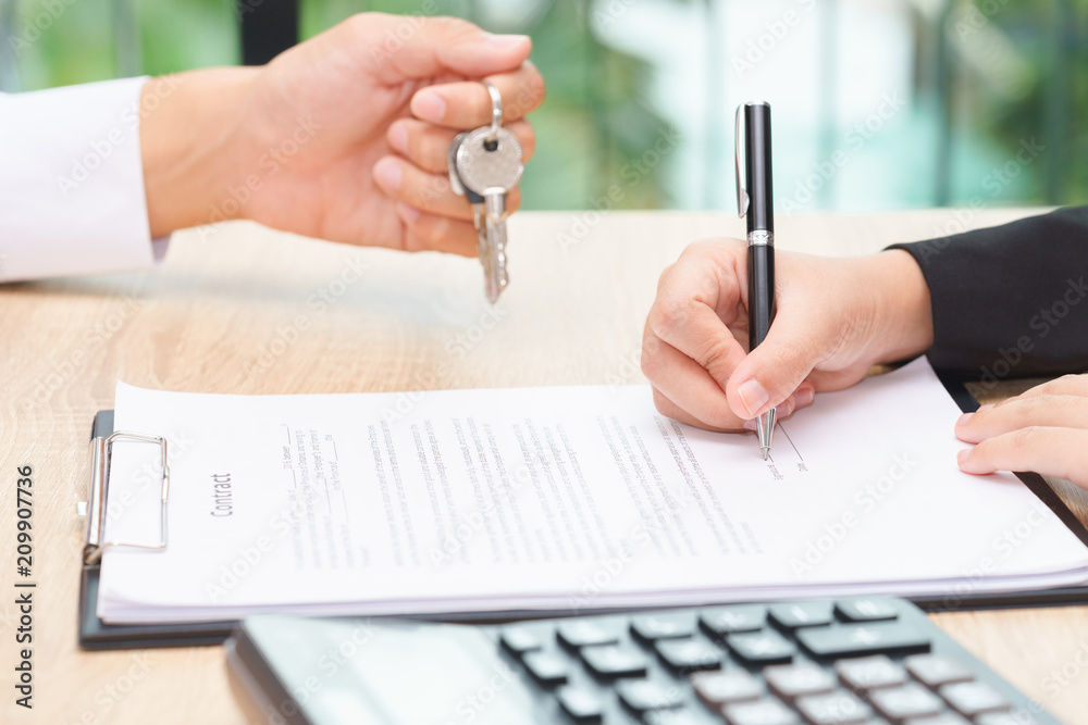 Businessman giving key over contract document with customer sign ...