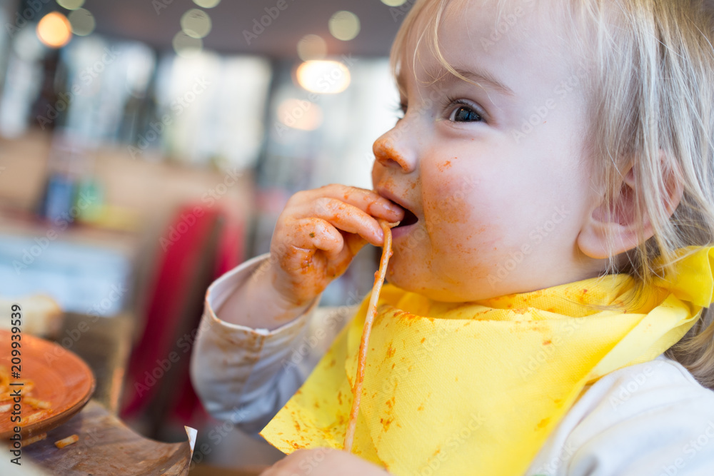 Bebé niña comiendo espaguetti con las manos Stock Photo | Adobe Stock