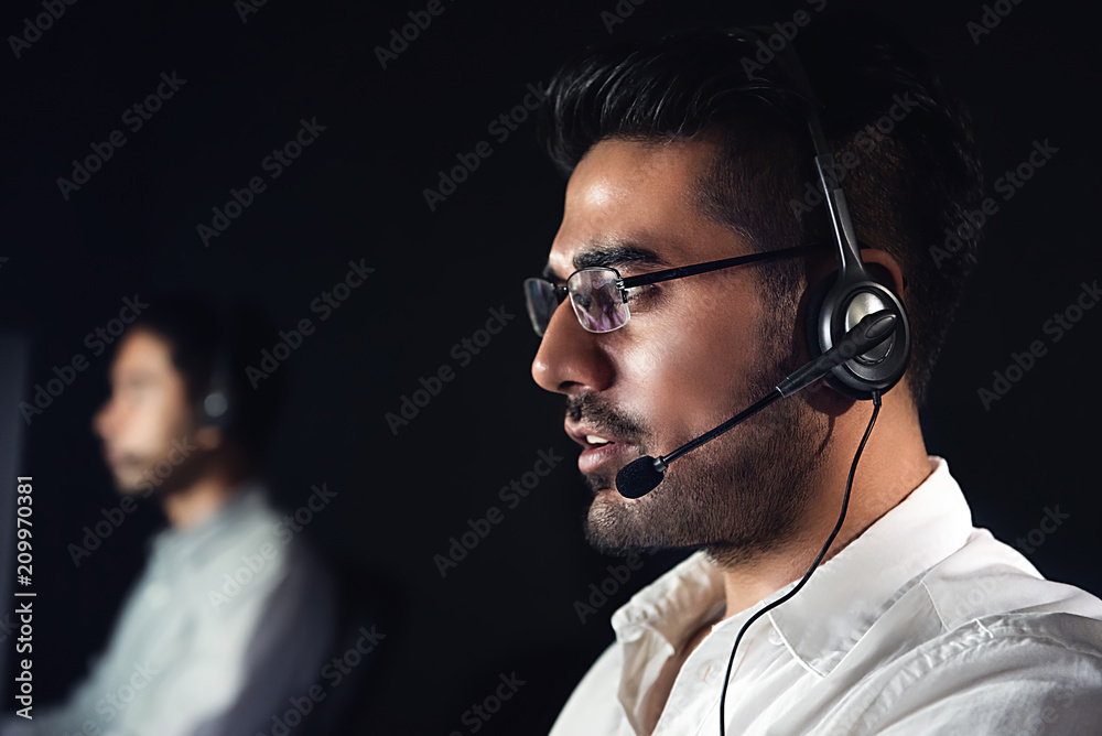 Asian male customer service operators working night shift in call ...