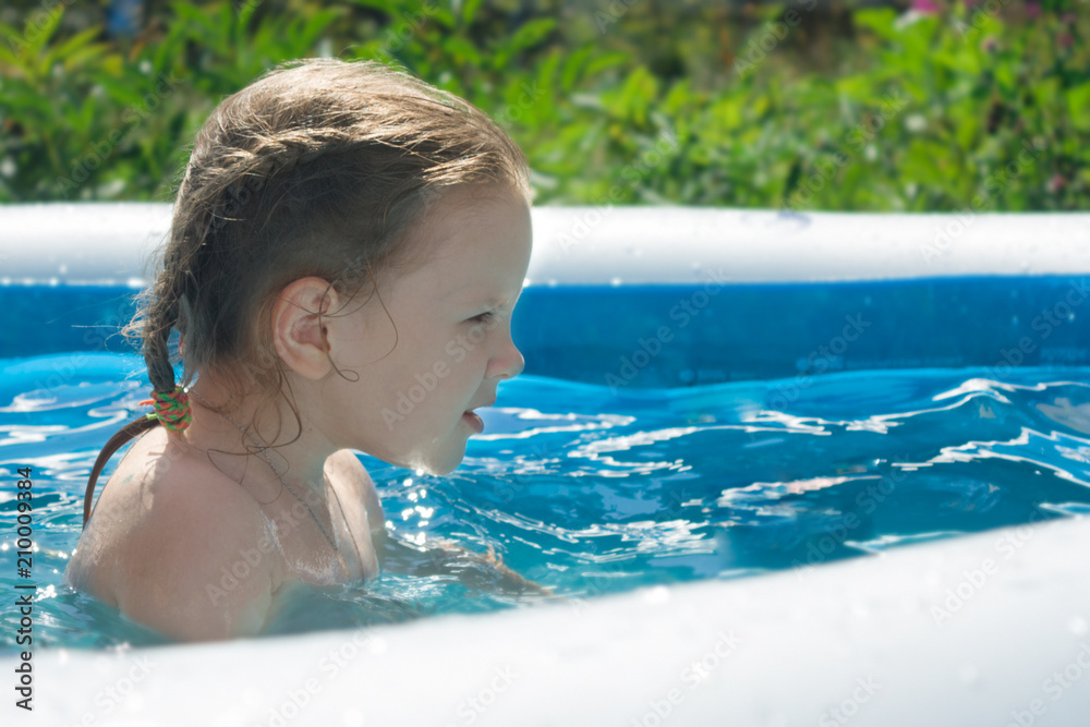 The girl smiles, squints from the sun, the child is pleased with the ...