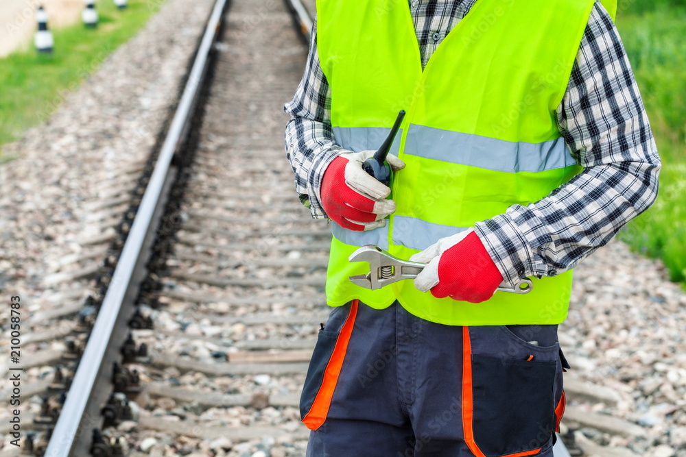 Worker with walkie talkie and wrench on railway Stock Photo | Adobe Stock