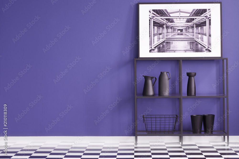 Black shelf with decorations, poster on a purple wall and geometrical ...