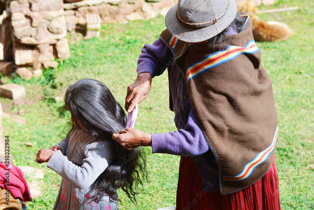 Native american grandmother combing hair of her granddaughter in the ...