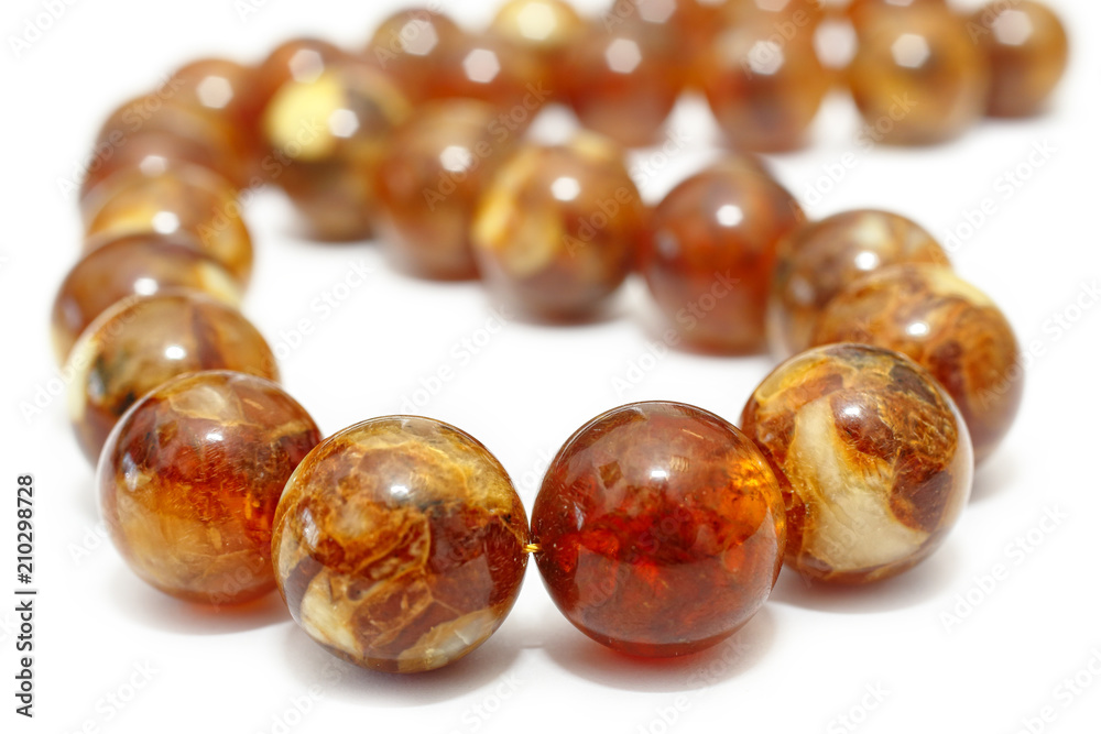 Amber. Beads made from natural yellow brown amber mineral on a white ...