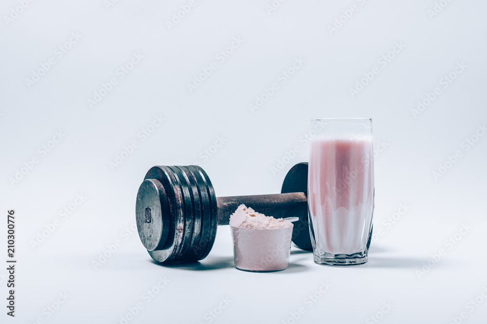 Whey protein shake in a glass next to scoop of powder Stock Photo ...