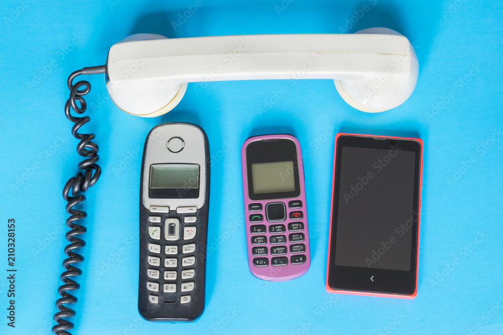 Technology evolution concept, old and new telephones on the blue ...