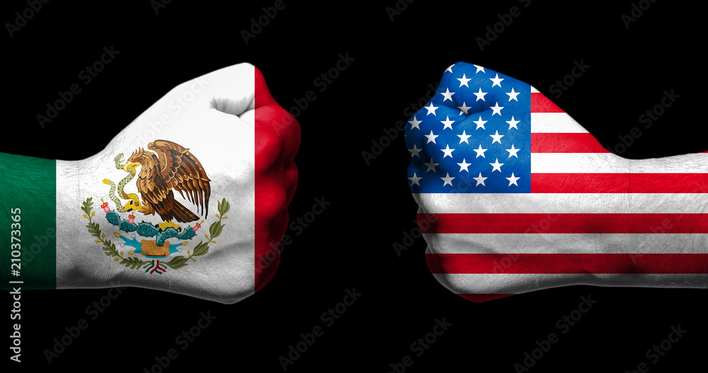 Flags of Mexico and United States painted on two clenched fists facing ...