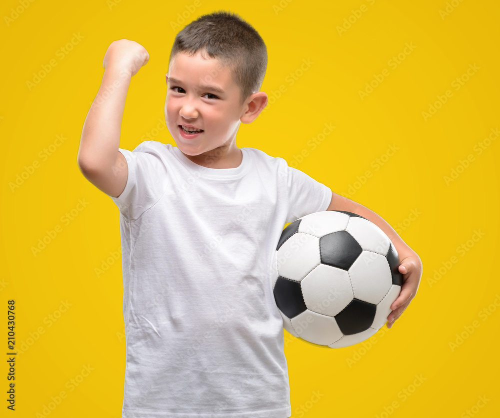 Dark haired little child playing with soccer ball annoyed and ...