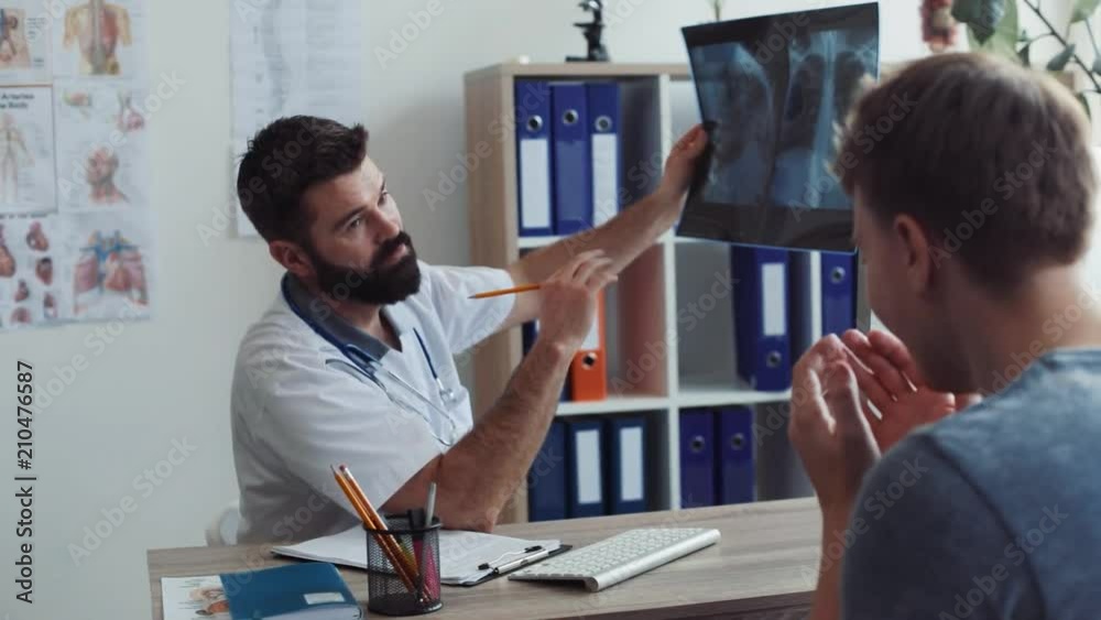 Experienced doctor showing X ray to sick patient. Caucasian medical ...