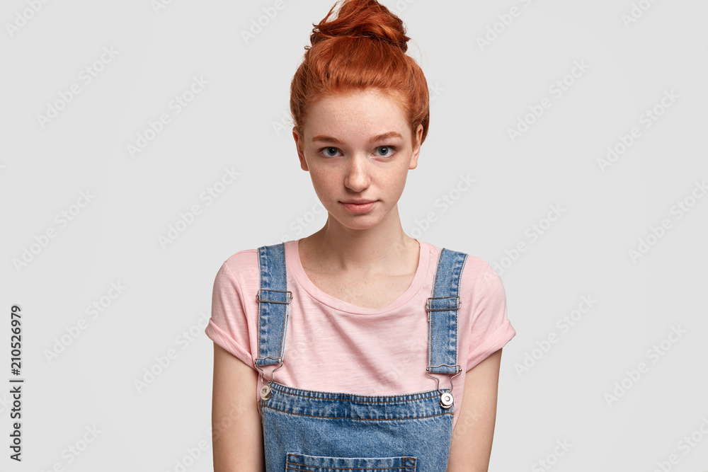 Studio shot of serious foxy female teenager look confidenlty, listens ...