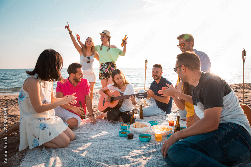 Multicultural group of friends partying on the beach – happy young ...