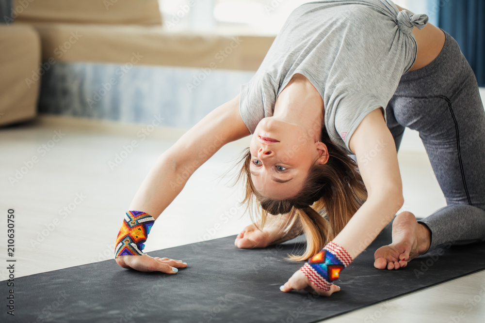 Young female yoga trainer in supta virasana recycling hero pose ...
