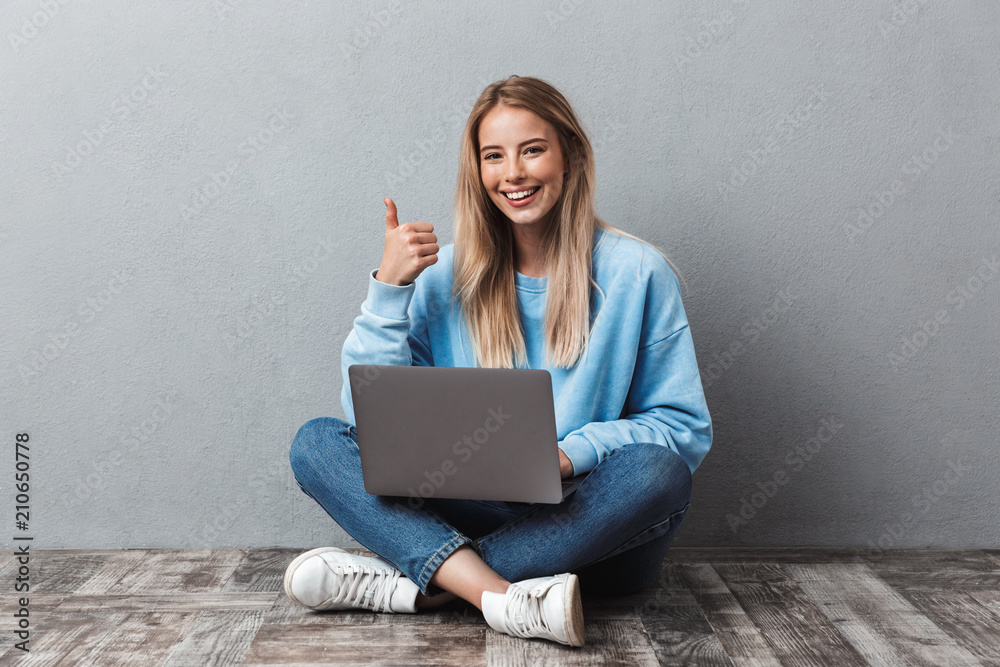 Smiling young blonde girl using laptop computer Stock Photo | Adobe Stock