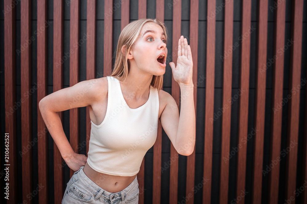 A picture of girl in white shirt standing in position of calling ...