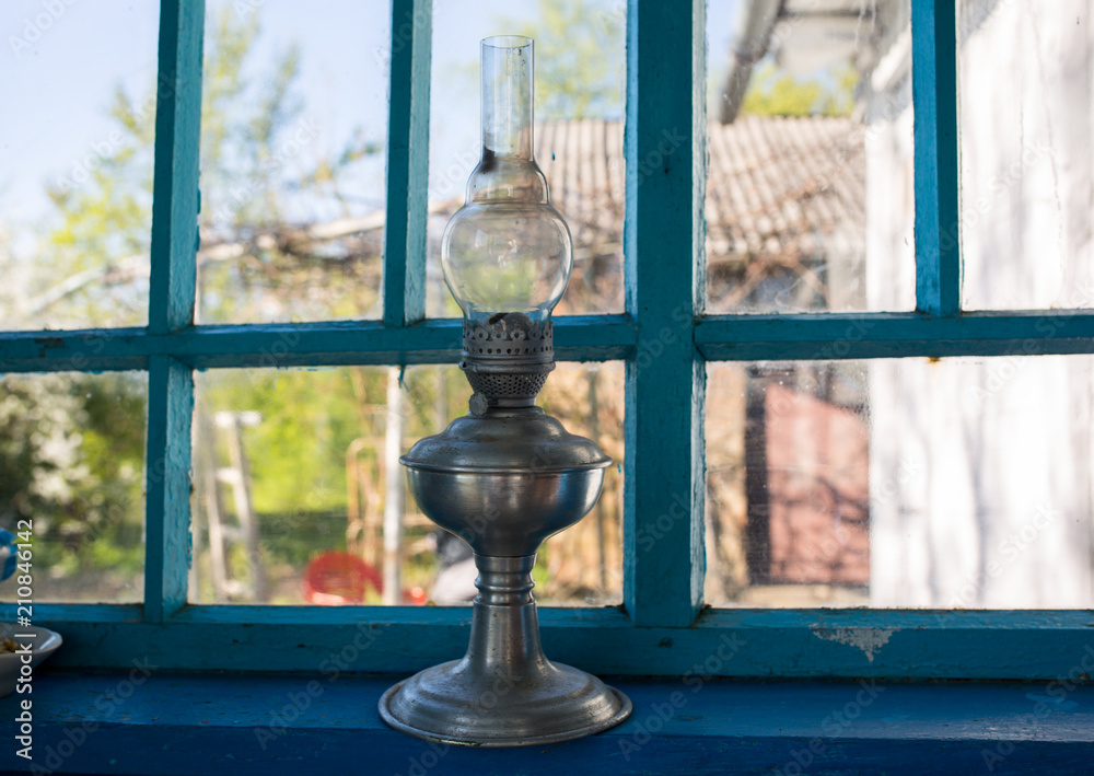 Old vintage gas lamp standing in the house on blue scratched window ...