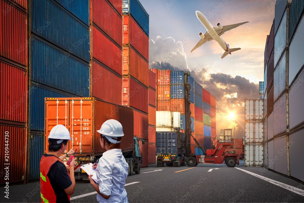 Foreman and Asian female dock worker control loading Containers box to ...
