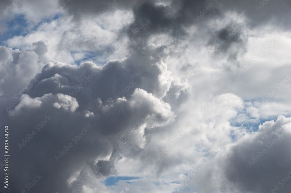 Stormy billowing clouds with blue sky. Moody oppressive weather with ...