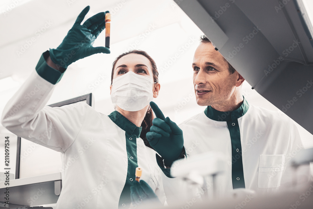 Unusual color. Portrait of concentrated laboratory scientists holding ...