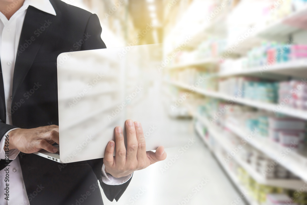Hand of Businessman, Manager use computer in supermarket with Blur ...