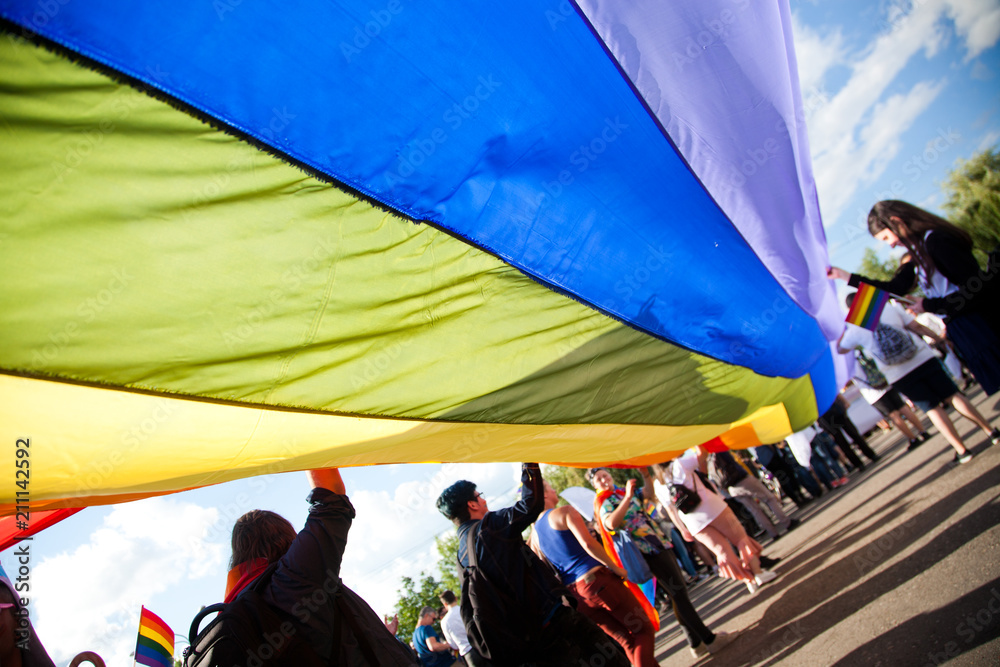 people holding giant rainbow flag at pride parade - LGBT symbol Stock ...