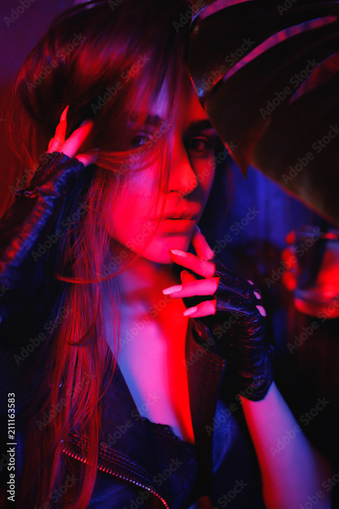 Portrait Of Sexy Girl With Long Hair In Leather Jacket Seated