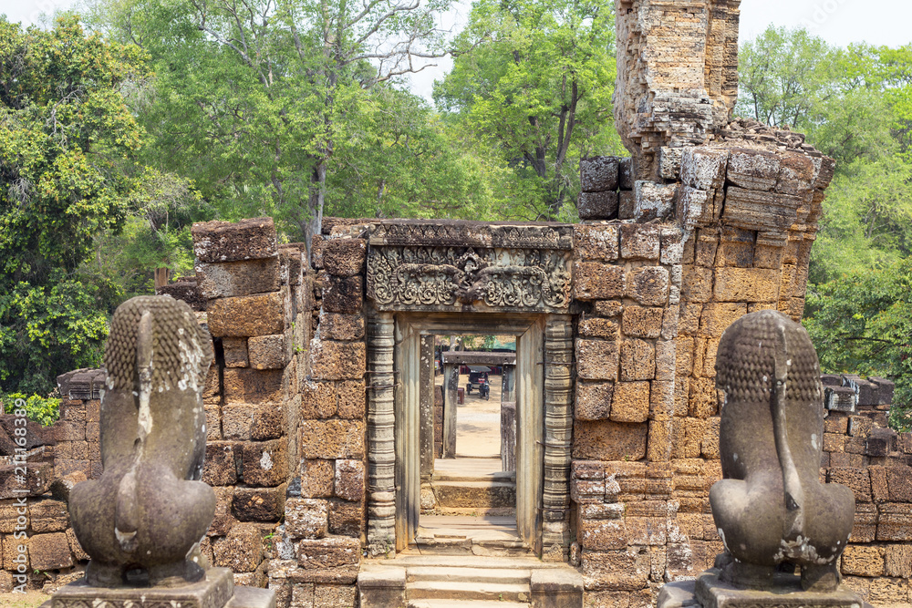 Ancient stone ruin in Angkor Wat temple. Small shrine with lion statue ...