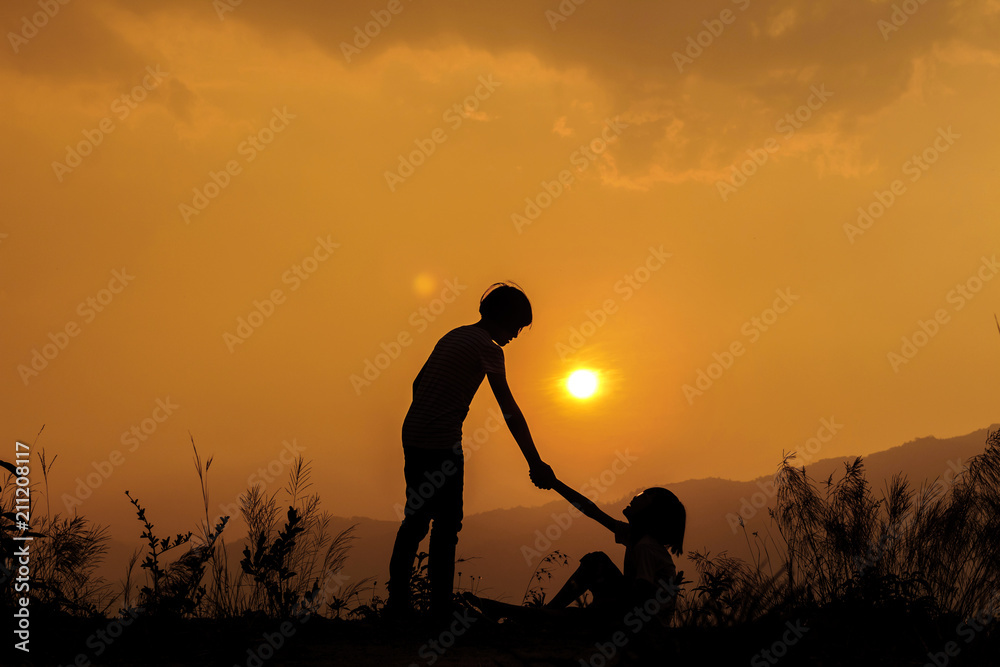 silhouette of little girl helping sister at sunset time, Stock Photo ...