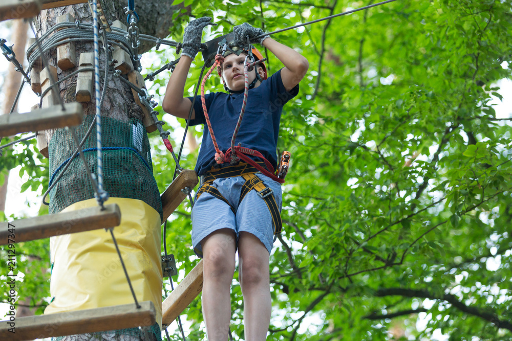 cute sporty 10 year boy is doing activity in adventure rope park with ...