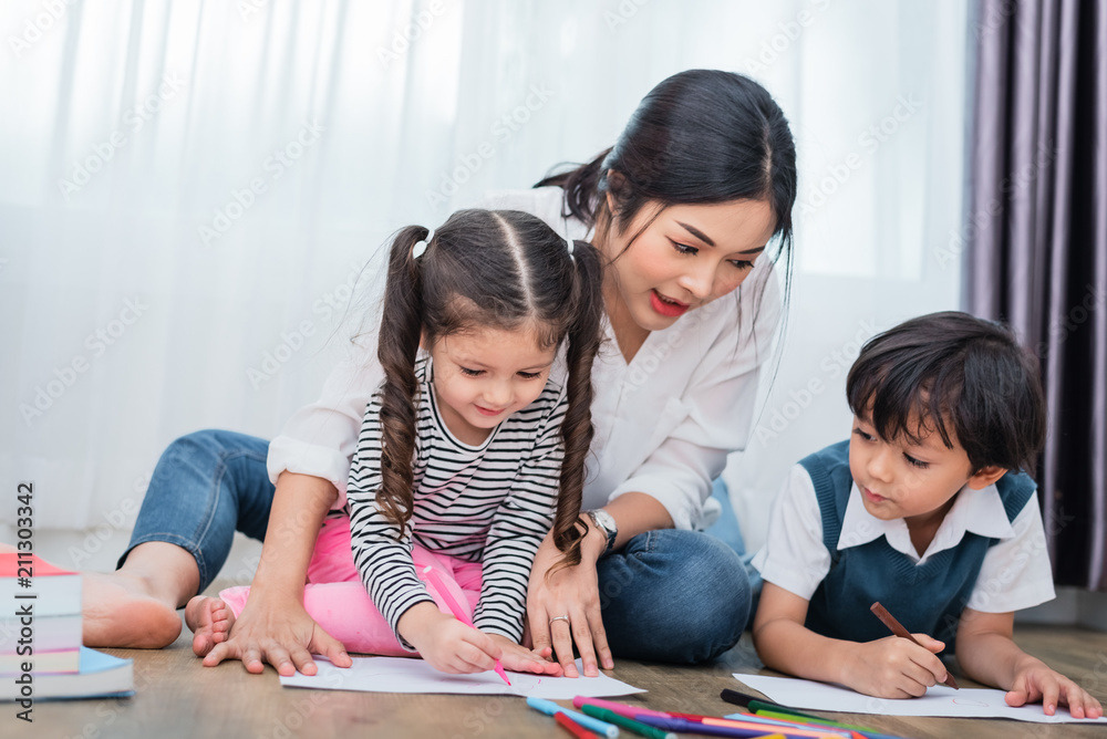 Mother teaching children in drawing class. Daughter and son painting ...