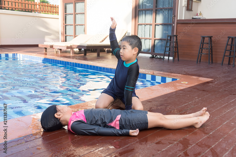 Boy helping drowning child girl in swimming pool by doing CPR. Stock ...