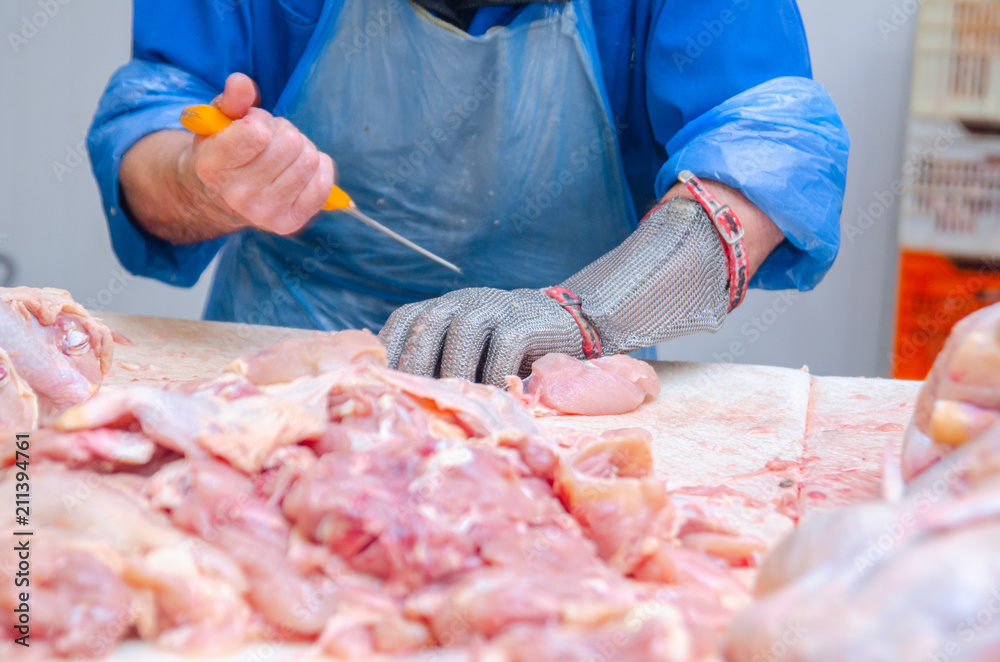 Chicken. Cutting shop of a poultry farm. Butcher is chopping a chicken ...