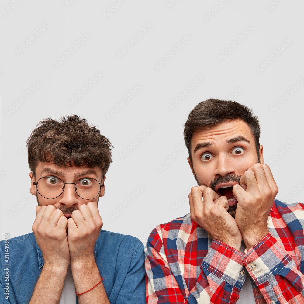 Nervous attractive two hipsters bite fingernails with worried ...