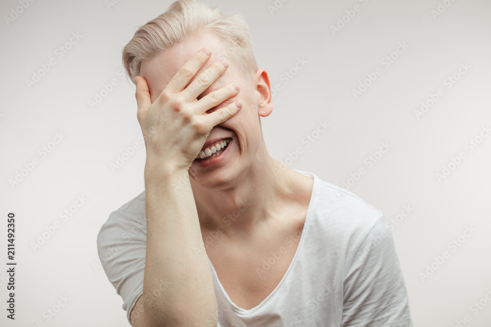 Emotional overjoyed Albino male model grabbing his face from laughing ...