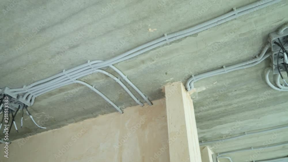 Electrical installation of plastic tubes on building site. Fix boxes ...