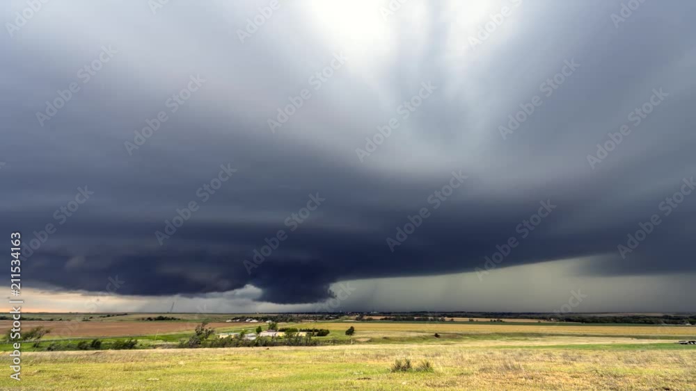 Large, powerful tornadic supercell storm moving over a small town in ...