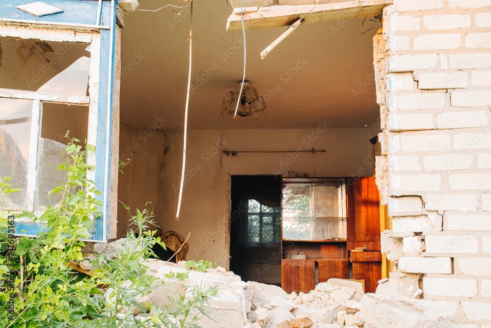 Ruined wall of the house. Hit a military projectile after a car ...