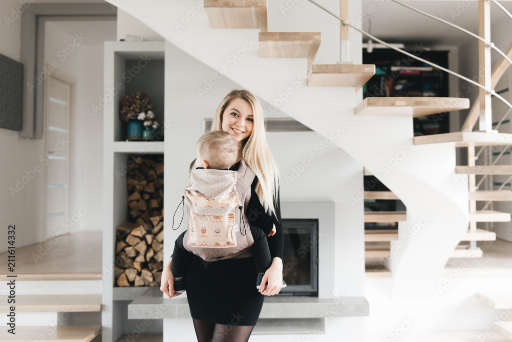 Stylish young mom keeps in ergo backpack of her cute year-old baby at ...