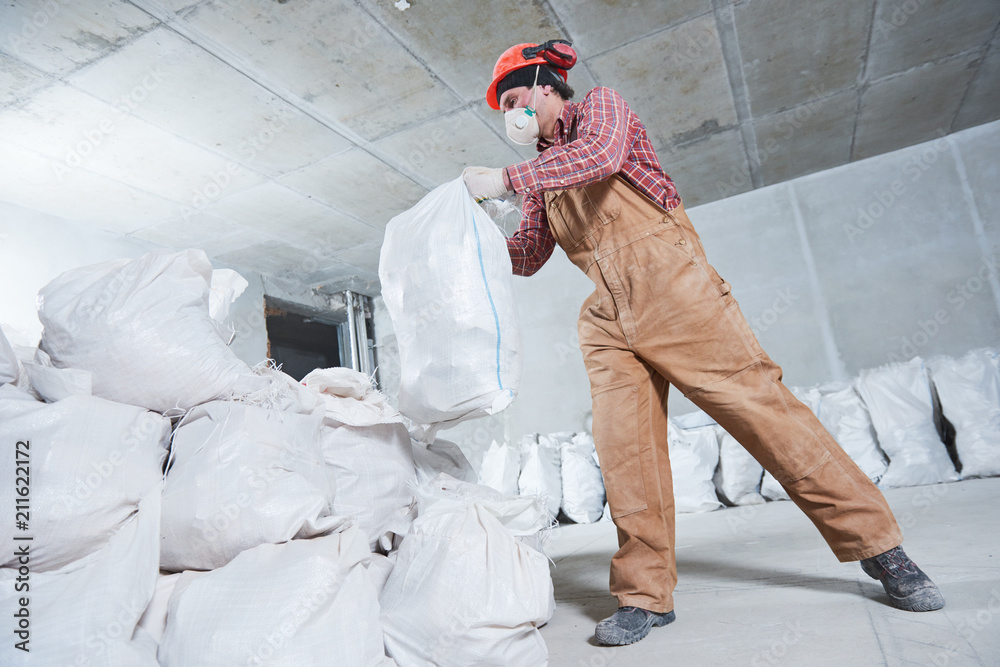 Worker collecting construction waste in bag Stock Photo | Adobe Stock