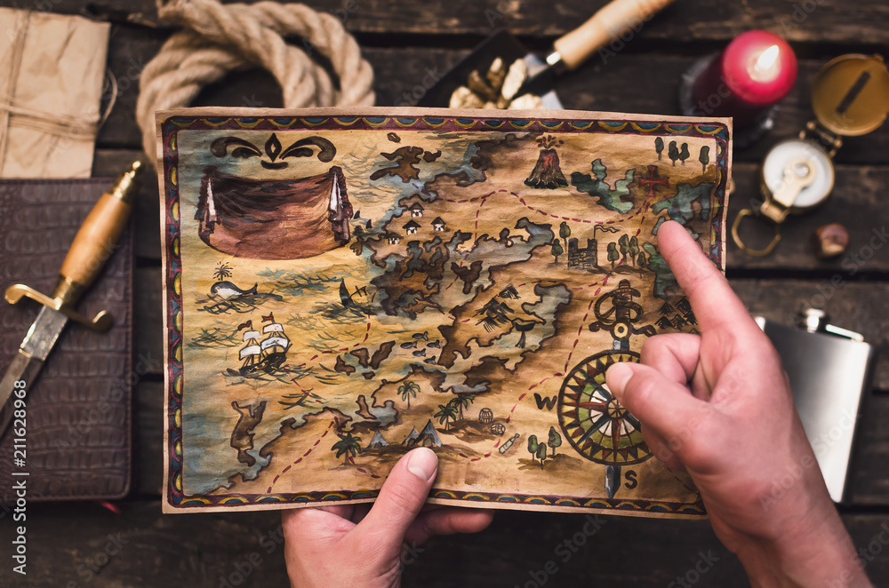 Treasure map in treasure hunter hands. Pirate man learning an old map ...