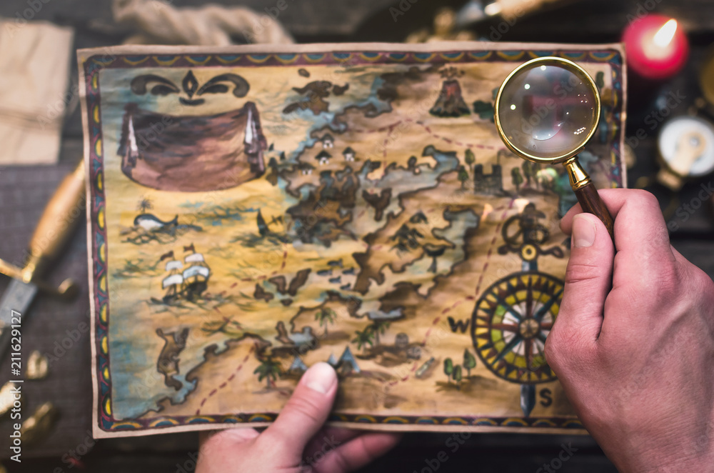 Treasure map in treasure hunter hands. Pirate man learning an old map ...