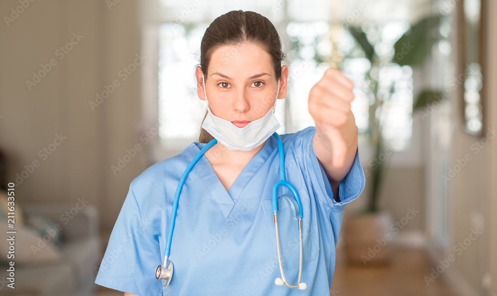 Young nurse woman wearing mask and stethoscope with angry face ...