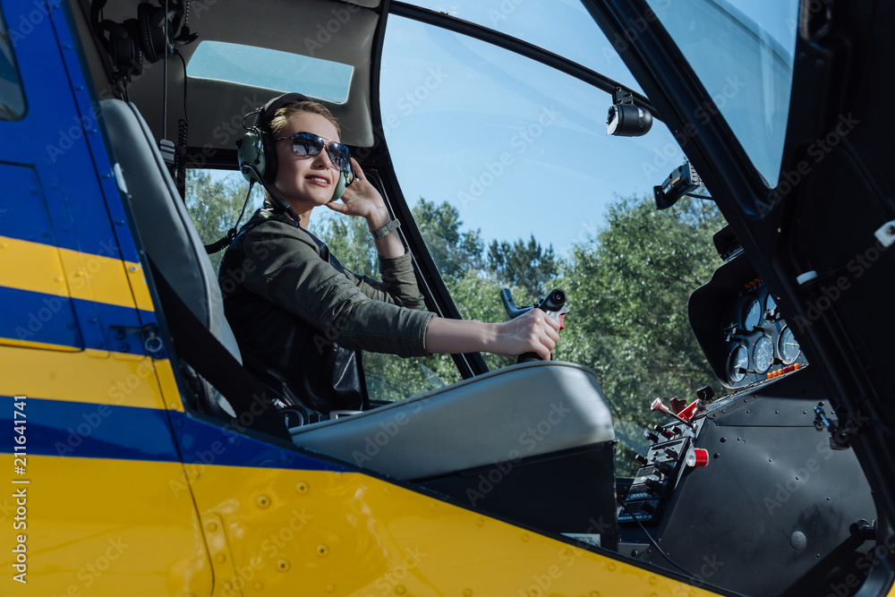 Keen on flying. Gorgeous young female pilot sitting in the pilot booth ...